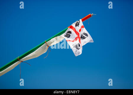 Traditional Four Moors flag of Sardinia's Region against Medieval town ...