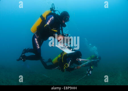 professional Scuba divers perform an underwater survey of the ...