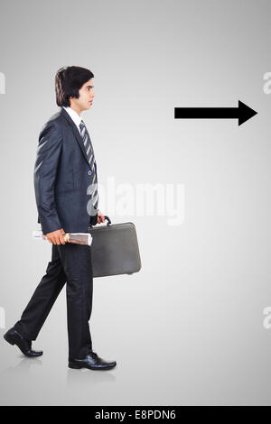 Businessman walking with arrows on the background and briefcase on his ...