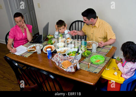 Distracted family at the dinner table Stock Photo - Alamy