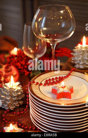 Empty red plate dish with a Christmas cap and cutlery on a blue wooden ...