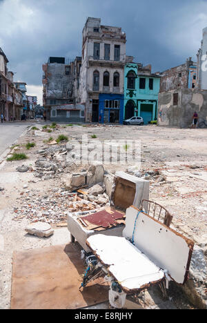 An empty corner lot strewn with old furniture debris from ruins of a ...