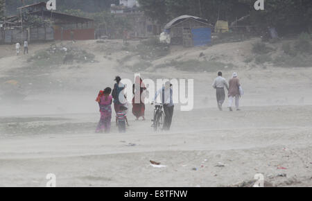 Allahabad, India. 13th October, 2014. People walk through a sandstorm ...