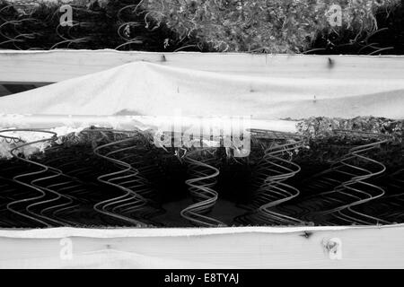 torn and broken spring mattress dumped in the front garden of a house ...