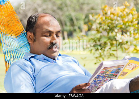 happy indian man reading book in bed at night Stock Photo - Alamy