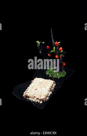 Vertical shot of grilled meat with vegetables in a black plate on a ...