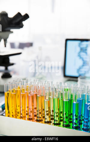 Rack with group of tubes and laboratory microscope Stock Photo - Alamy