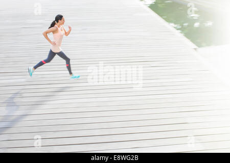 Woman running through city streets Stock Photo - Alamy
