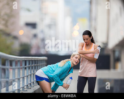 Happy young woman resting after workout on blue background. Healthy ...