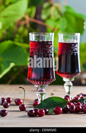 cherry brandy and ripe berries on wooden table Stock Photo - Alamy