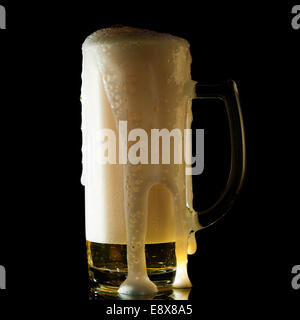 Overflowing beer mug Stock Photo - Alamy