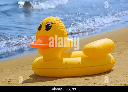Inflatable Swimming duck Ring floating in the pool. Yellow plastic duck ...