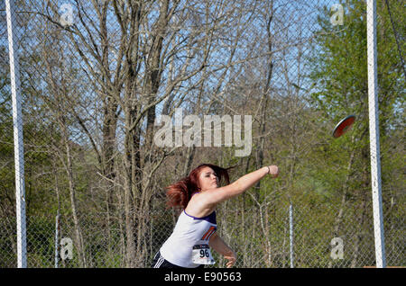 Girl throwing a disk in a high school dicus throwing event at a track ...