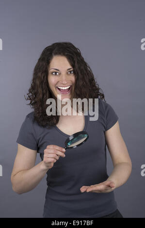 Magnifying glass in front of the face Stock Photo - Alamy