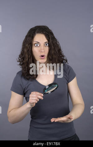 Magnifying glass in front of the face Stock Photo - Alamy