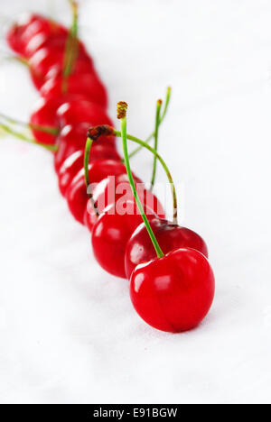 row line of ripe summer cherries cherry fruit on a colourful colorful ...
