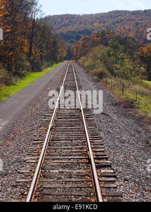 Railroad tracks recede into the distance with mountains at sunset Stock ...