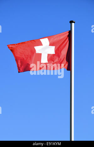 Flag of Switzerland waving in the wind against deep blue sky. Swiss ...