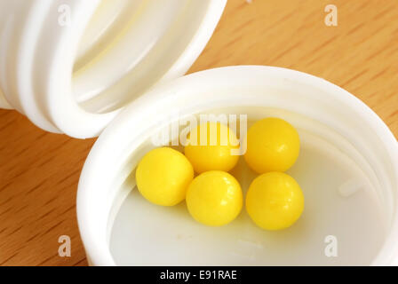 Yellow dragee pills Stock Photo - Alamy