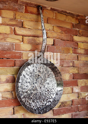 Old rusty frying pan hanging on green wall of cabin Stock Photo - Alamy