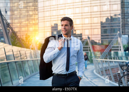 Close-up of handsome businessman in black suit, smiling amazed, showing ...