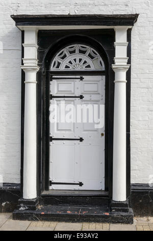 white and black classical door on white painted bricks facade with a ...