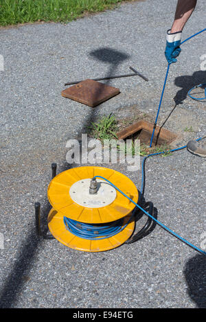 Geologist taking inclinometer readings on road, measuring slope ...