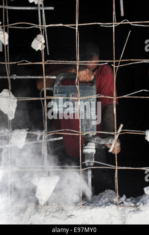 2 construction workers with jackhammers break up concrete on a city ...