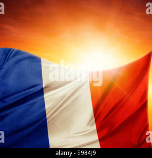French flag flying in bright blue sky in front of the Eiffel Tower in ...