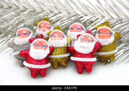 Some dolls of Santa Claus are together isolated on a white background ...