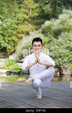 Serene young man crouching on ocean rock, Sayulita, Nayarit, Mexico ...