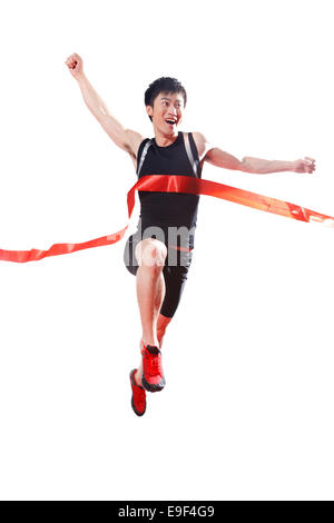 Low angle shot of a male muscular cyclist drinking water, standing near ...