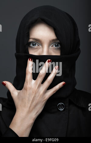 Close-up portrait of a girl with a terrible dead man mask on a dark ...