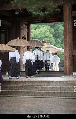 Shinto priest in traditional robes and congregation at ritual ceremony ...