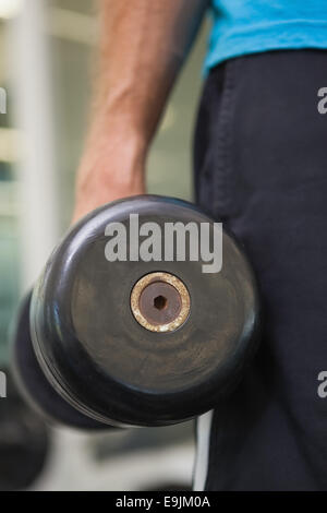Mid section of man holding dumbbell in gym Stock Photo - Alamy