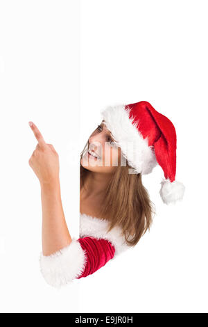 Attractive smiling brunette girl pointing fingers upper left corner ...