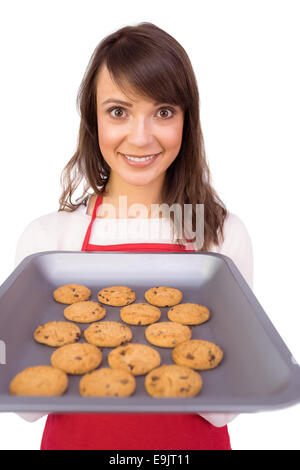 Festive brunette showing hot cookies on white background Stock Photo ...
