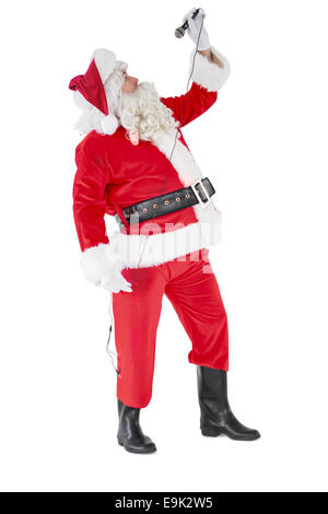 Happy santa claus singing with microphone against red snowflake ...
