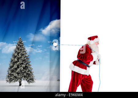 Composite image of santa claus pulling rope Stock Photo - Alamy