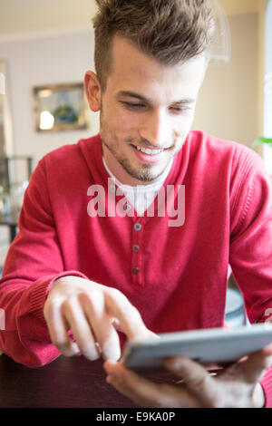 smiling man with tablet pc sitting on couch Stock Photo - Alamy