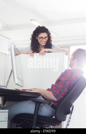 Business people talking over cubicle wall Stock Photo - Alamy