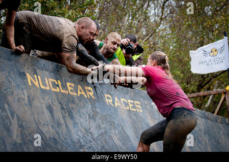 Participants battle against obstacles and mud in the 2014 Nuclear Races ...