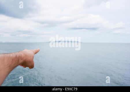 Finger pointing an island at the horizon on the sea Stock Photo - Alamy