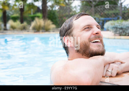 Man leaning on edge of swimming pool Stock Photo - Alamy