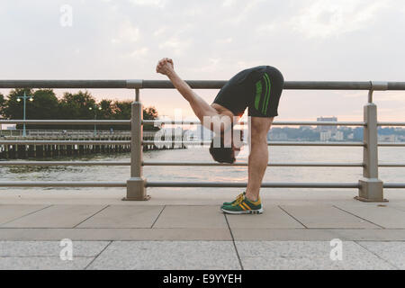 Young man bending down Stock Photo - Alamy