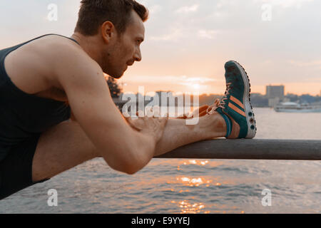 young man stretching touching toes flexible. studio white background ...