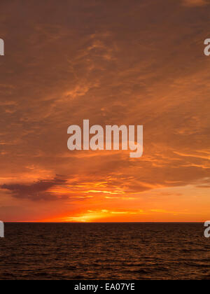 Seascape with beautiful sunset on horizon line and clouds, vertical ...