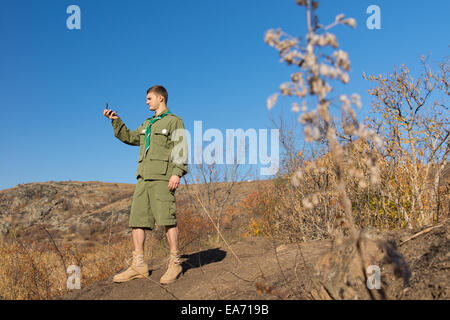 Muscular young man standing reading book with surprised expression ...