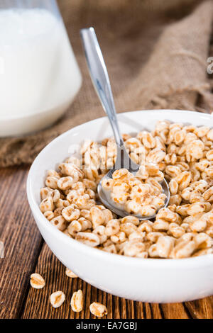Dry honey puffed wheat cereal pieces scattered loosely directly above ...
