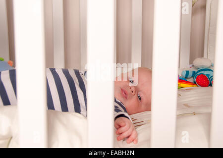 Baby just woken up in cot Stock Photo - Alamy